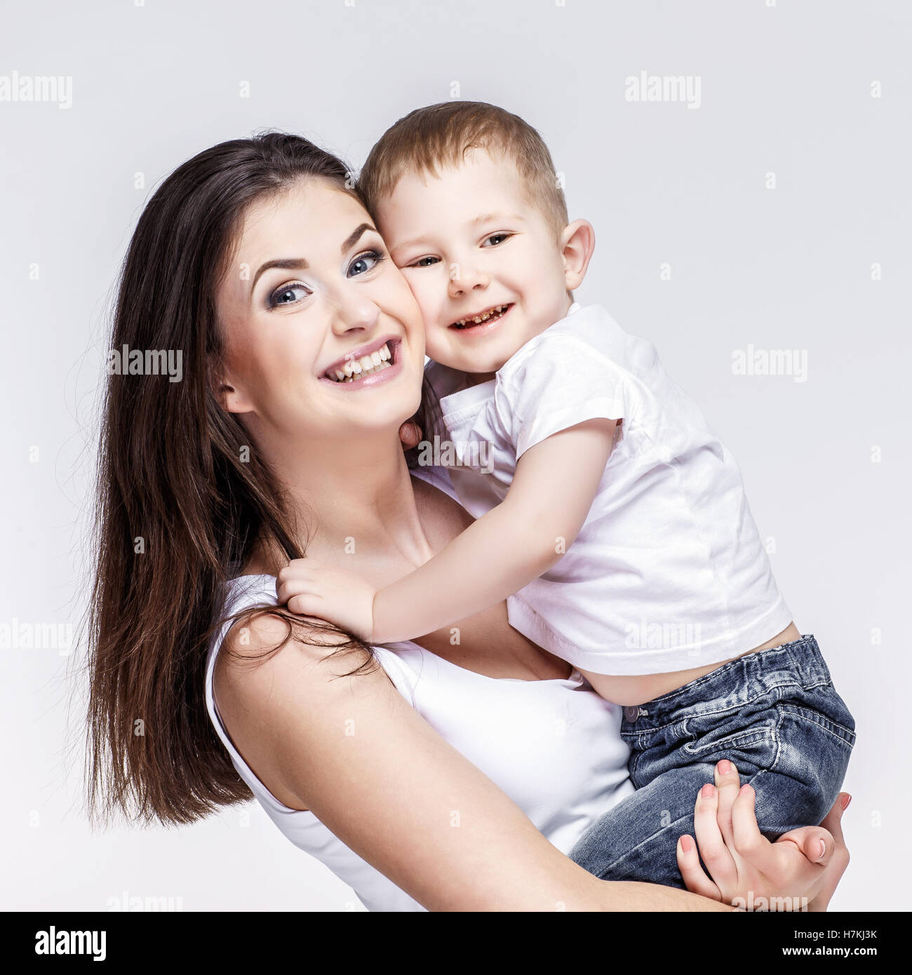 happy mother with a child on light grey background Stock Photo - Alamy