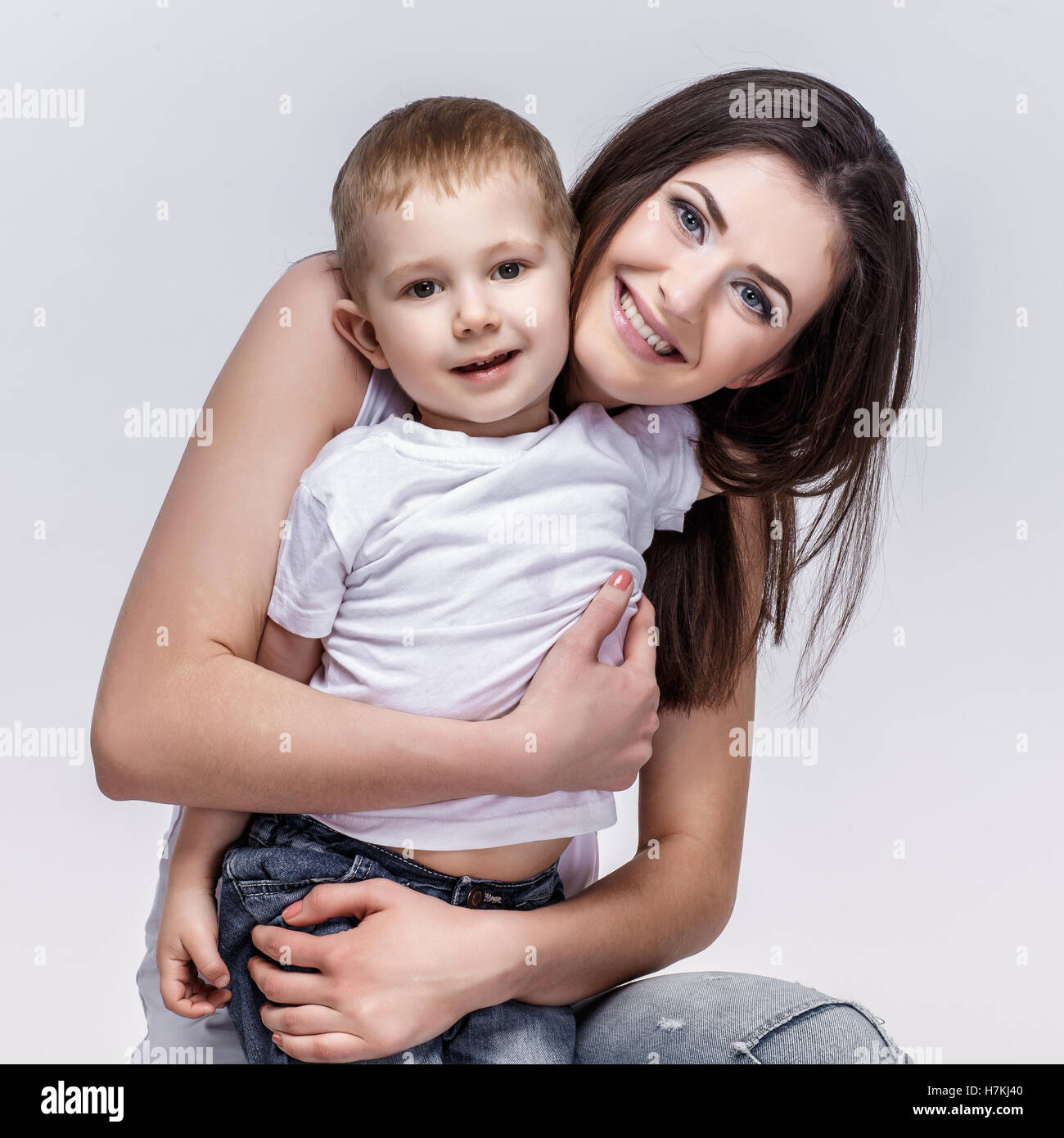 happy mother with a child on light grey background Stock Photo - Alamy