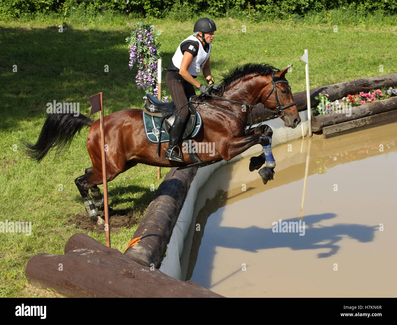 Rider on horse jumping over water during yearly cross country contest ...