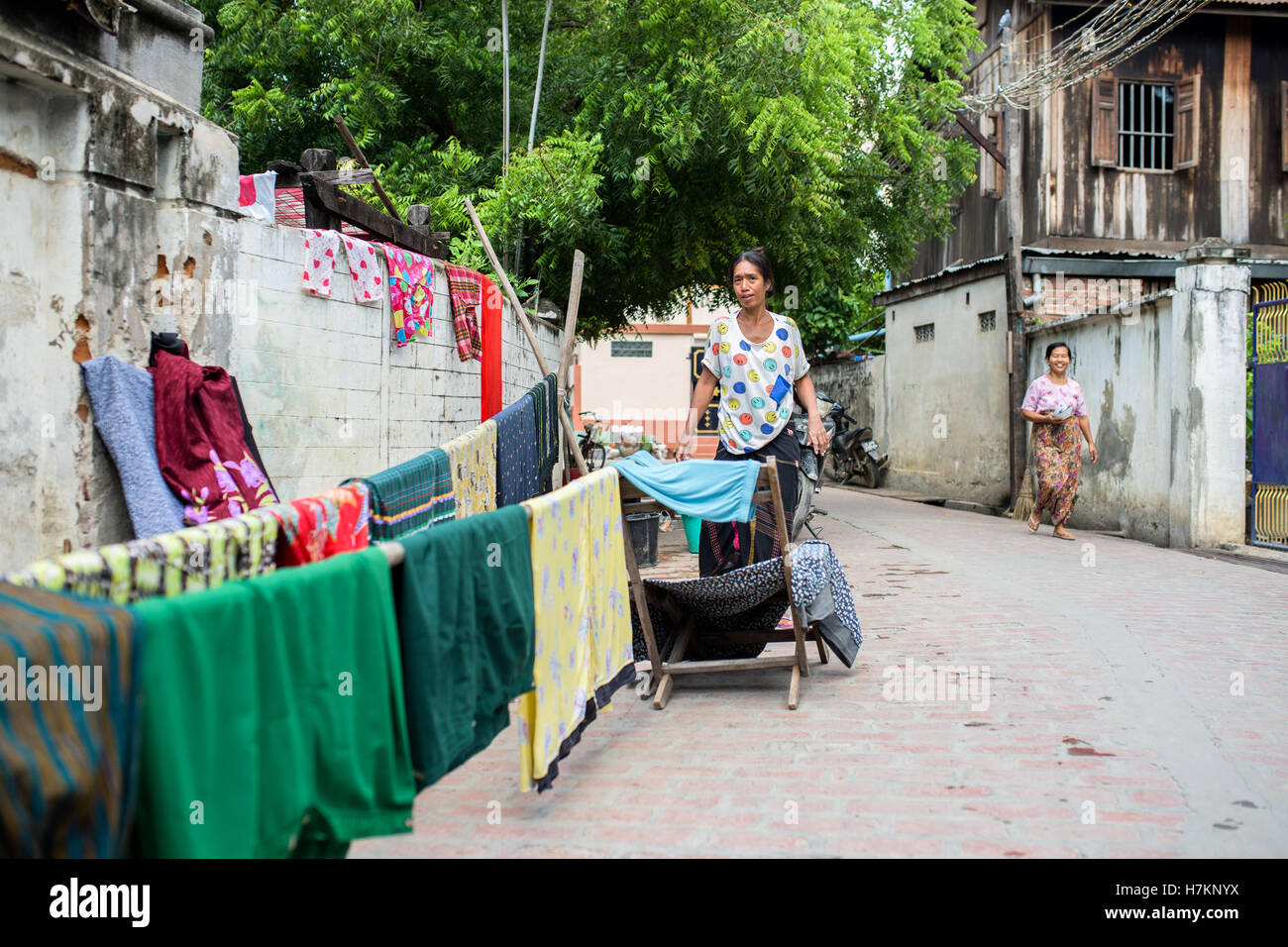 Woman hanging laundry in the streets of Mandalay, Burma (Myanmar Stock Photo - Alamy