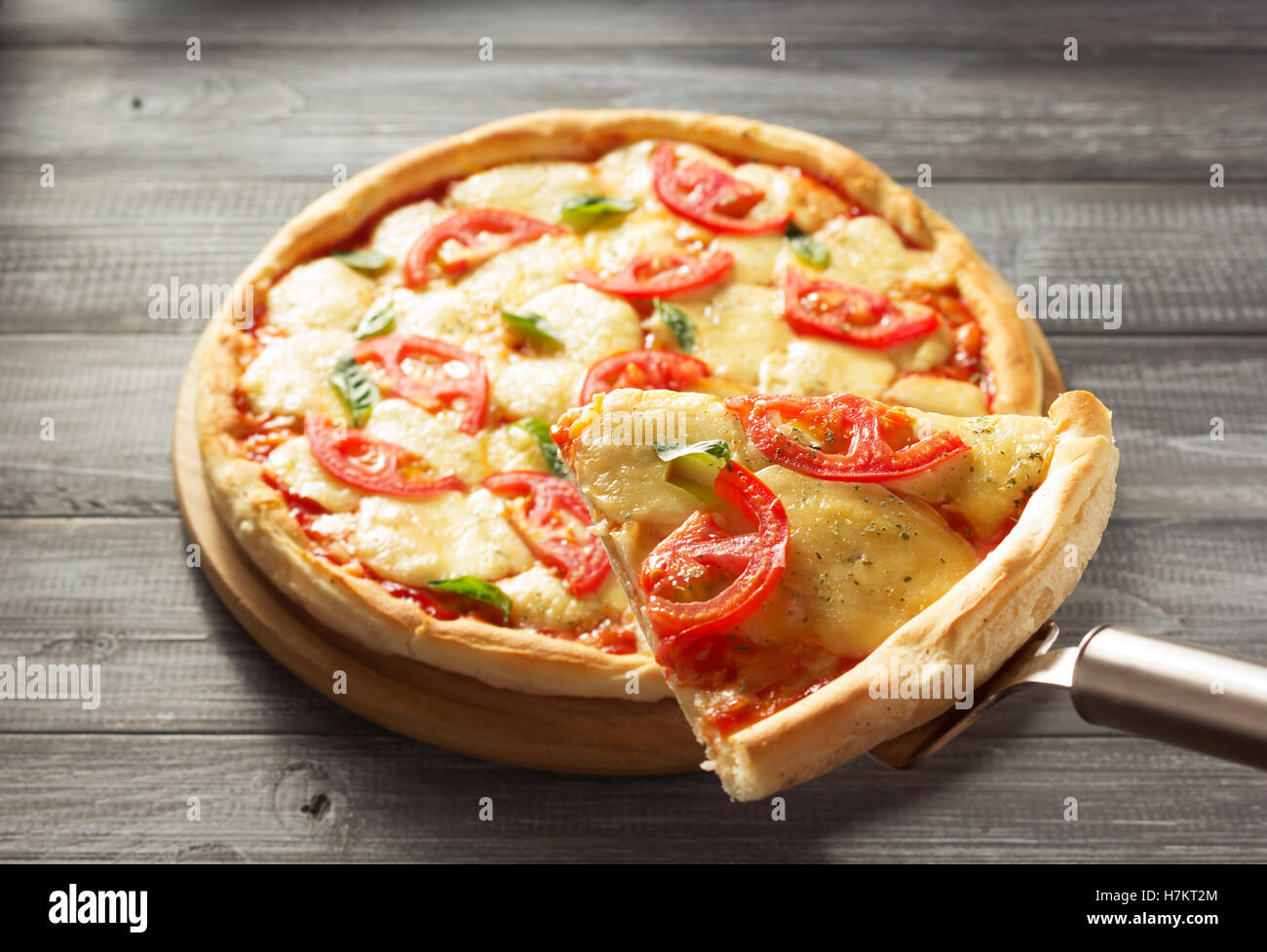 italian pizza at wooden table Stock Photo - Alamy