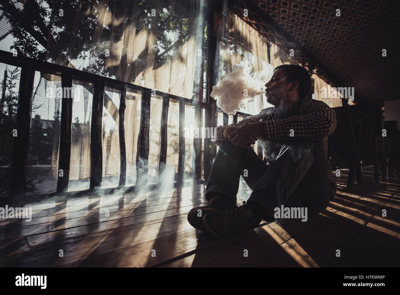 vaping young man produces vapor on sunset silhouette Stock Photo - Alamy