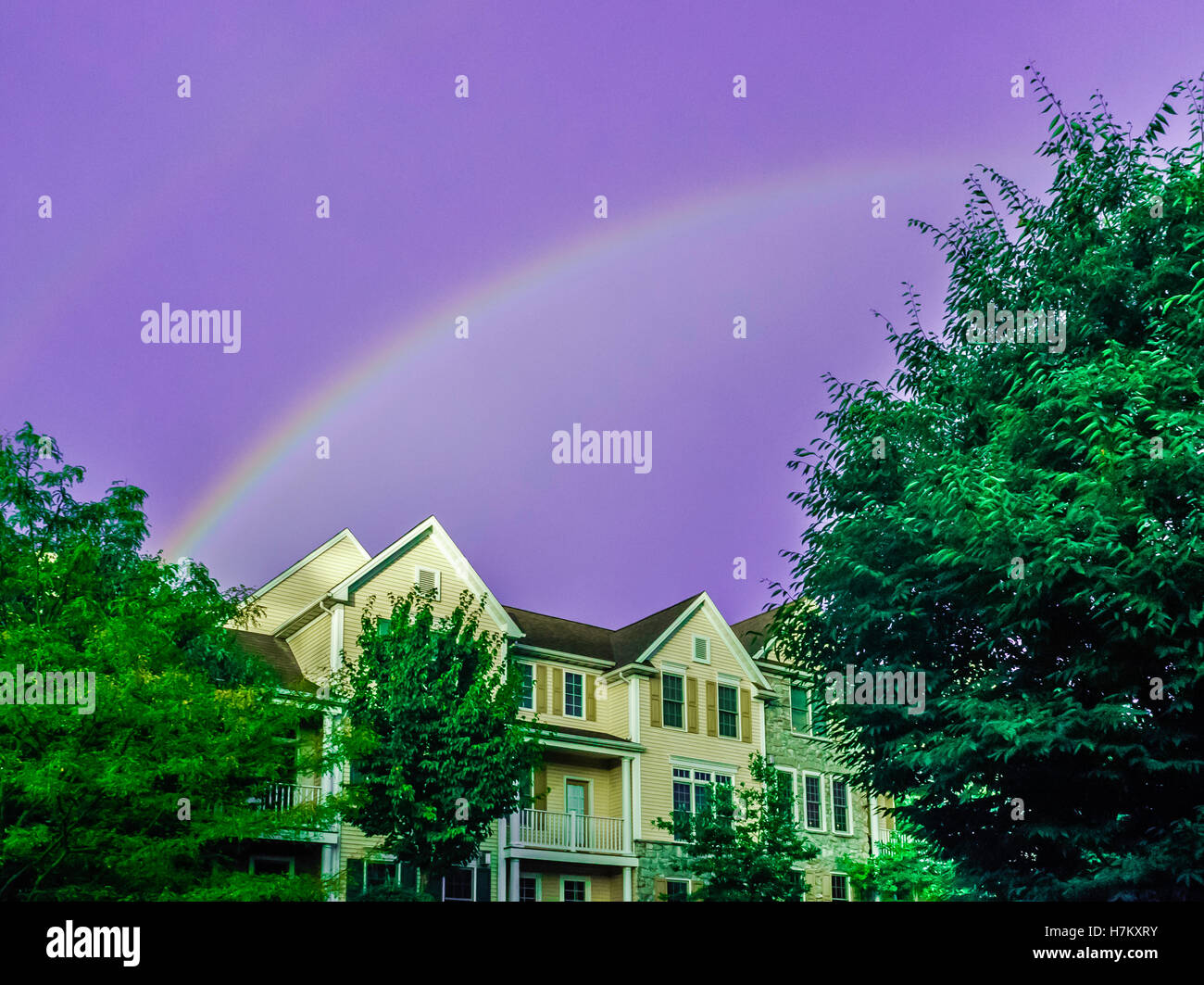 Rainbow over houses Stock Photo - Alamy