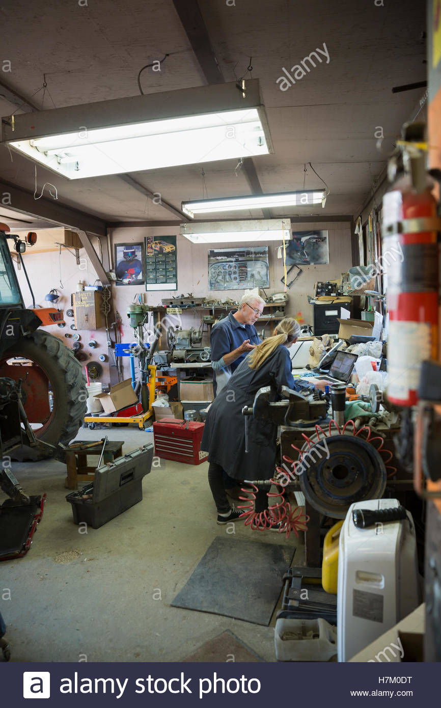 Mechanics working at laptop in workshop Stock Photo - Alamy