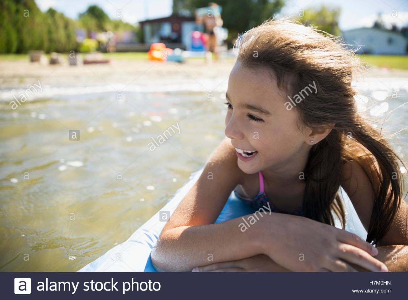 Smiling girl laying on inflatable raft on sunny summer lake Stock Photo ...