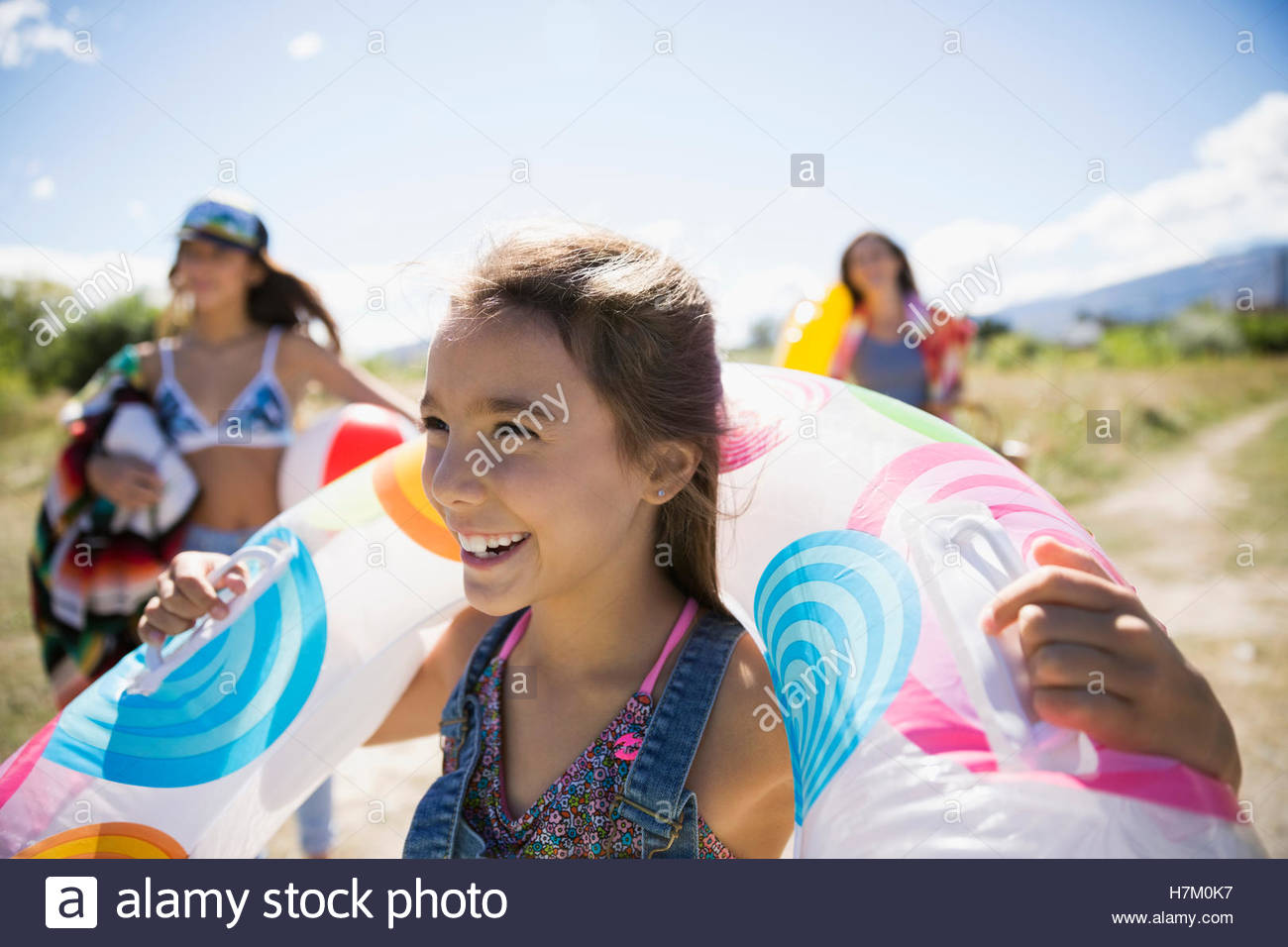 Smiling girl with inner tube in sunny summer field Stock Photo - Alamy