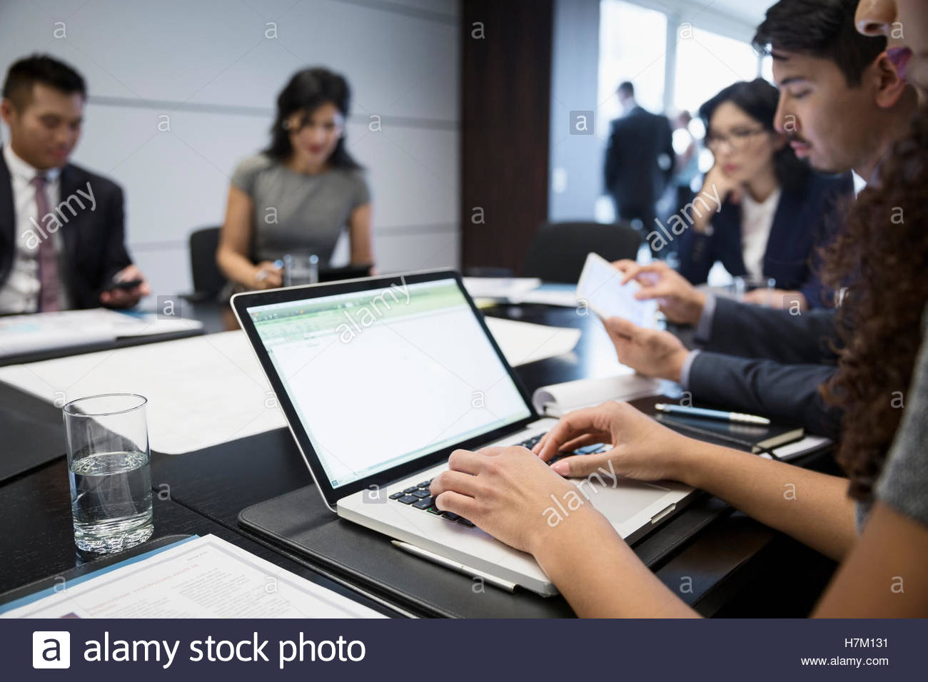 Architects using laptop and digital tablet in conference room meeting ...