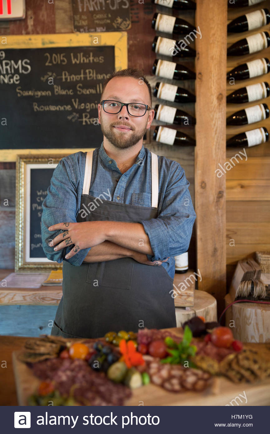 Portrait confident winery chef behind charcuterie board in tasting room ...