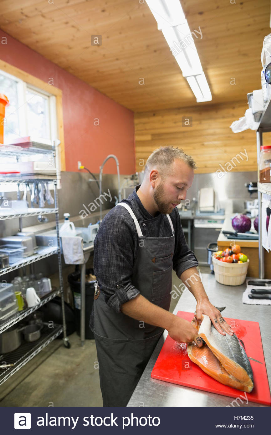 Chef filleting fish in restaurant commercial kitchen Stock Photo - Alamy