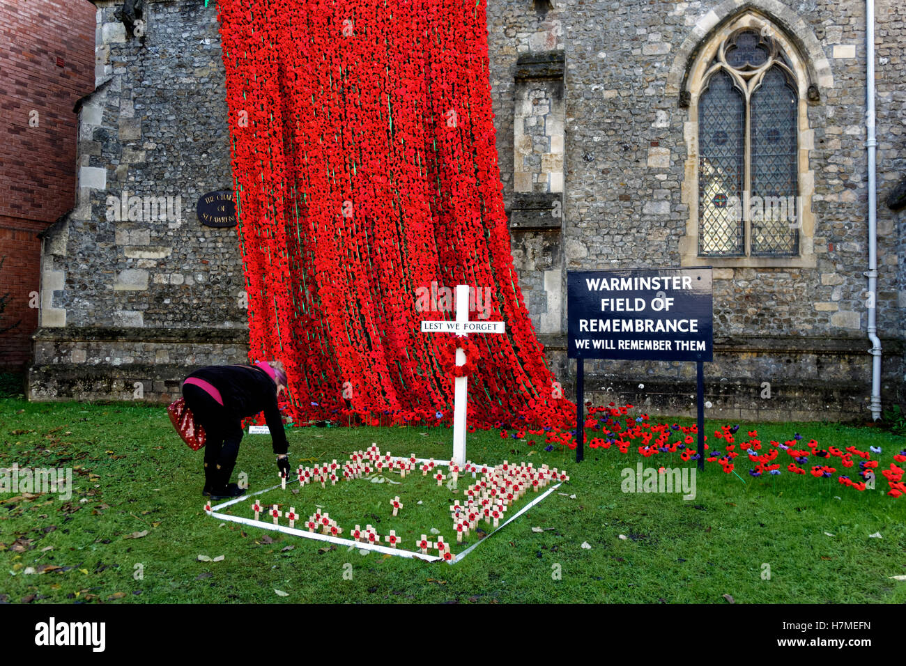 Warminster, Wiltshire, UK. 7th Nov 2016. A woman places a wooden cross ...