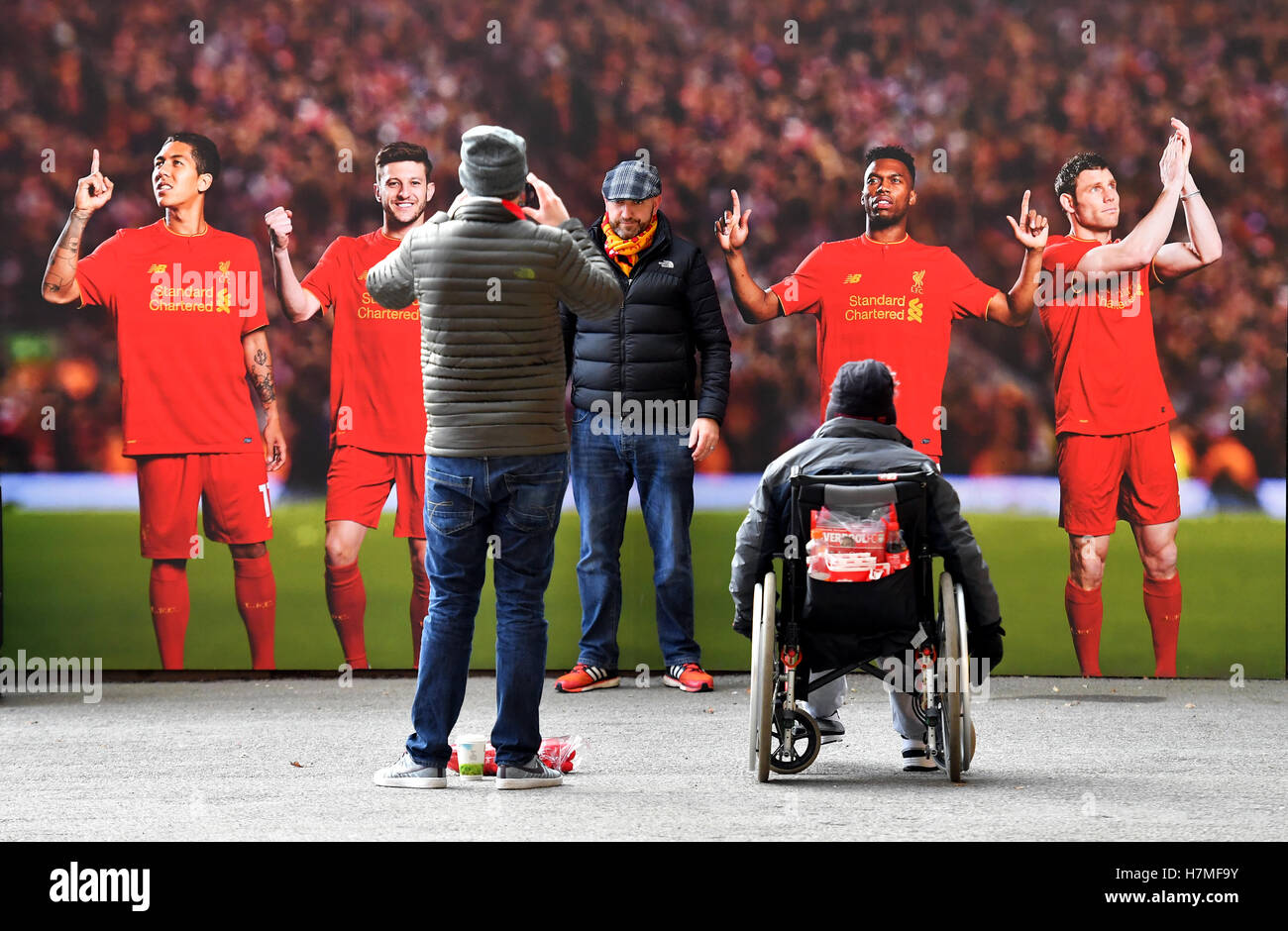 Liverpool fans pose for a picture in front of a board with players on ...