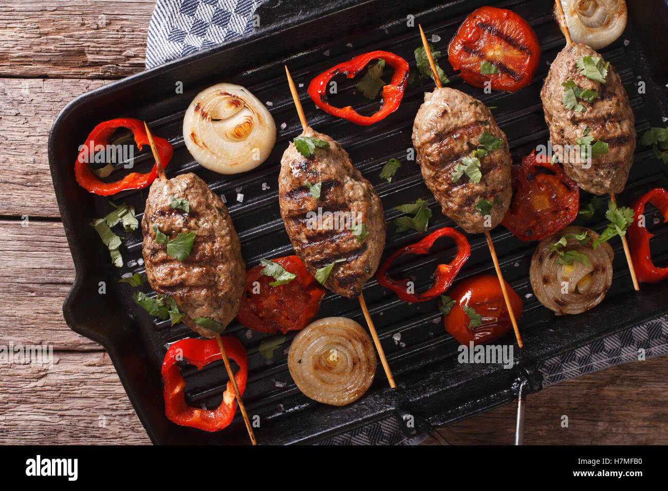 Kofta kebab with grilled vegetables on the grill pan close-up on the ...