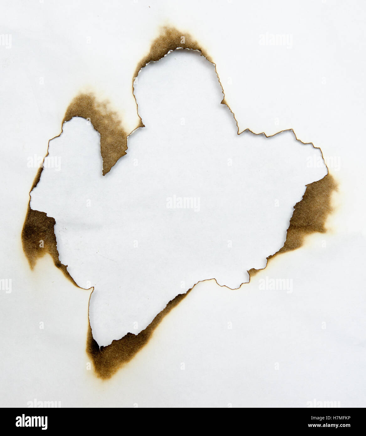 burned hole in a paper Stock Photo - Alamy