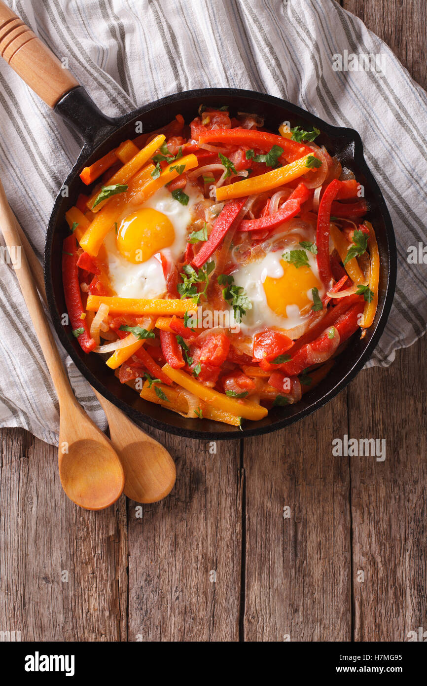 traditional Basque piperade with eggs close-up in a pan. vertical view ...
