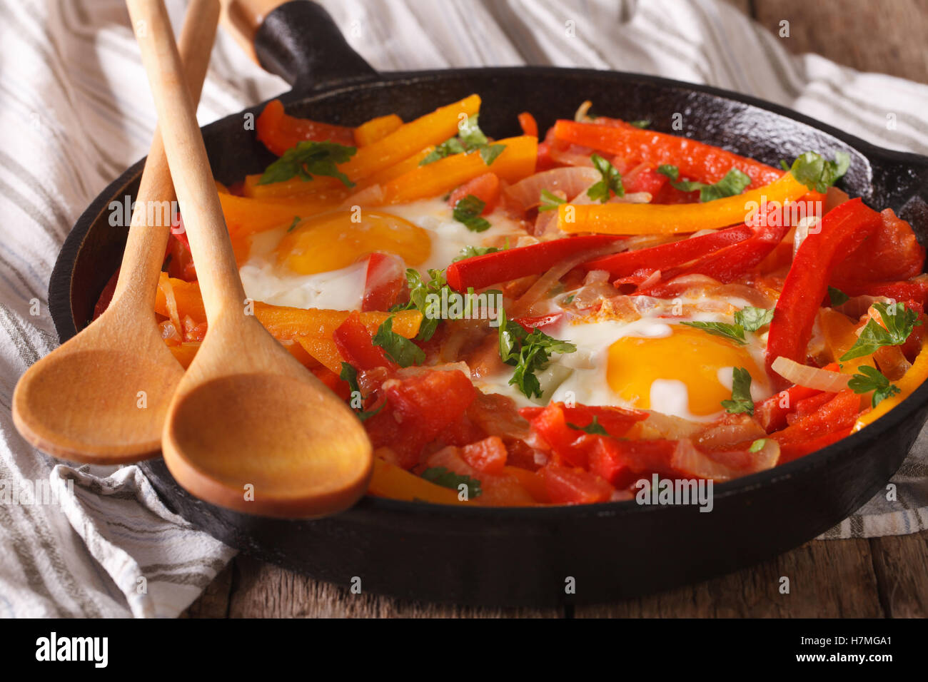Basque breakfast: fried eggs with peppers in a pan close-up. horizontal ...