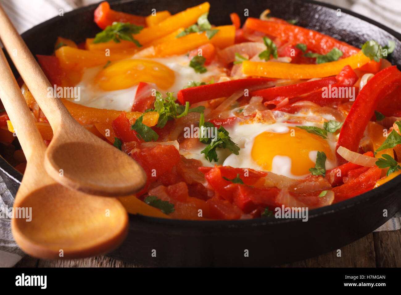 traditional Basque piperade with eggs close-up in a pan. horizontal ...