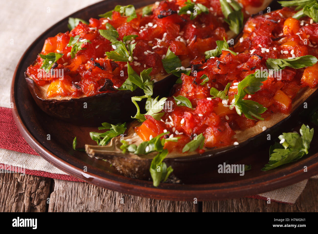 Imam bayildi. Baked eggplant stuffed with vegetables macro on a plate ...