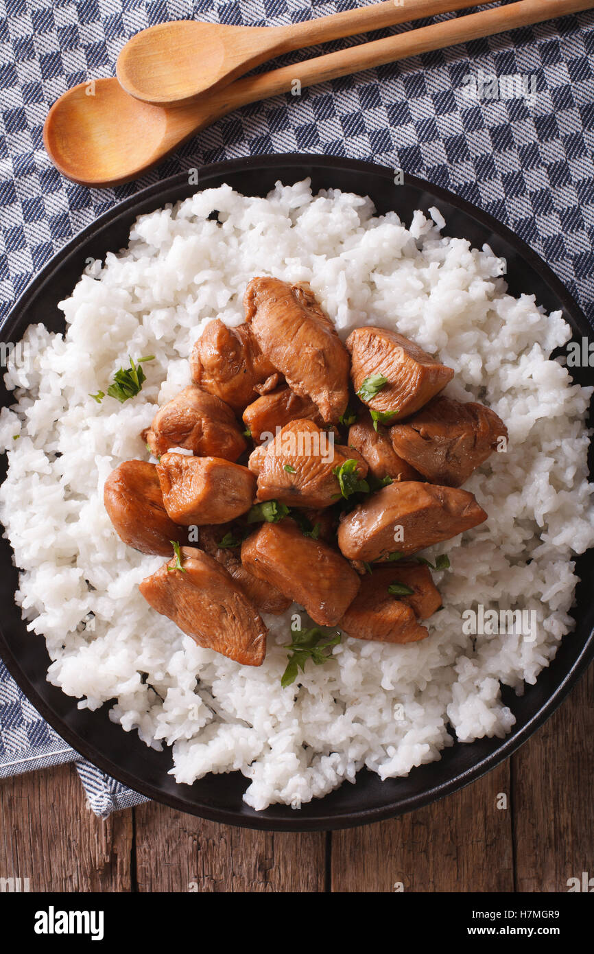 Adobo Chicken with a side dish of rice close-up on a plate. vertical ...