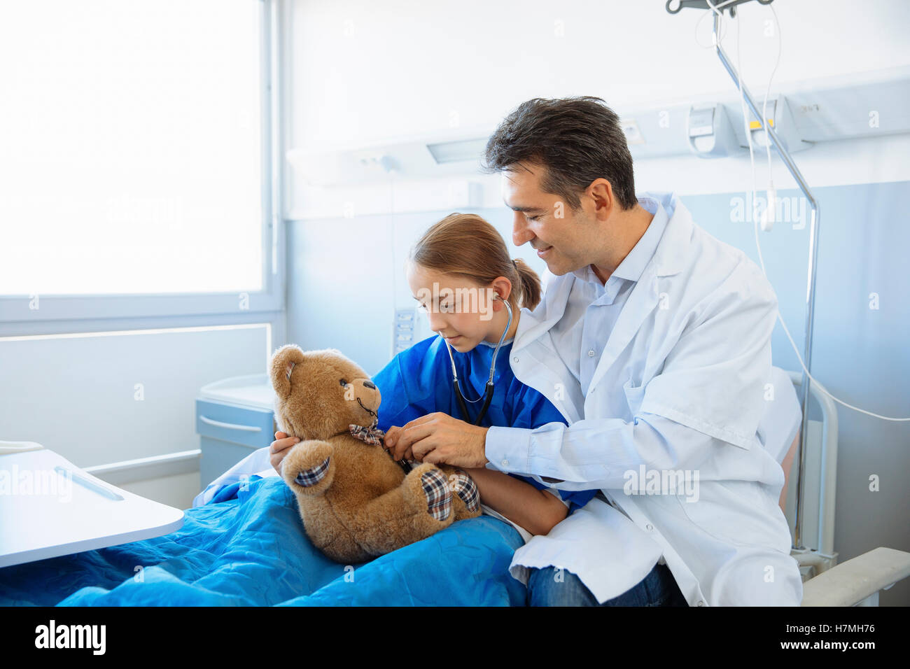 Doctor and girl patient examining a teddy bear Stock Photo - Alamy