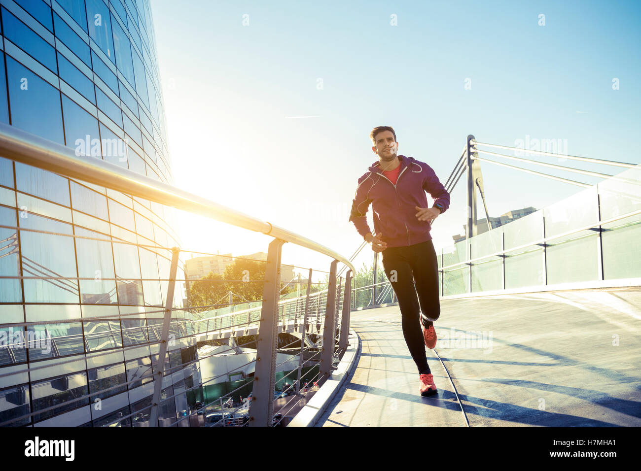 athlete with earphones running in the city Stock Photo - Alamy