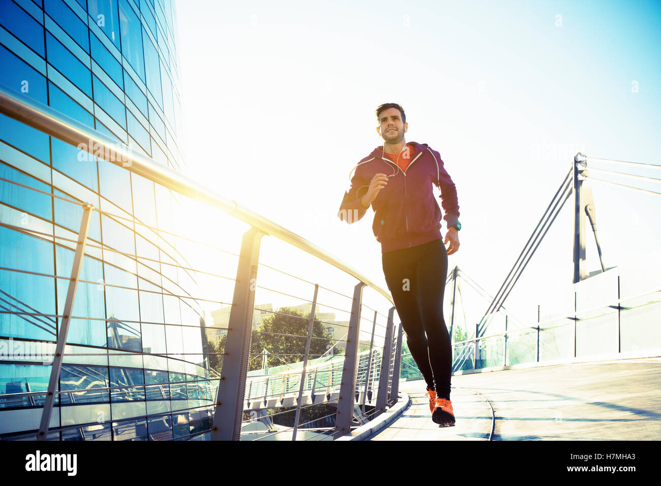 athlete with earphones running in the city Stock Photo - Alamy