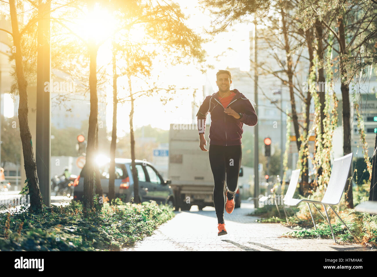 athlete with earphones running in the city Stock Photo - Alamy