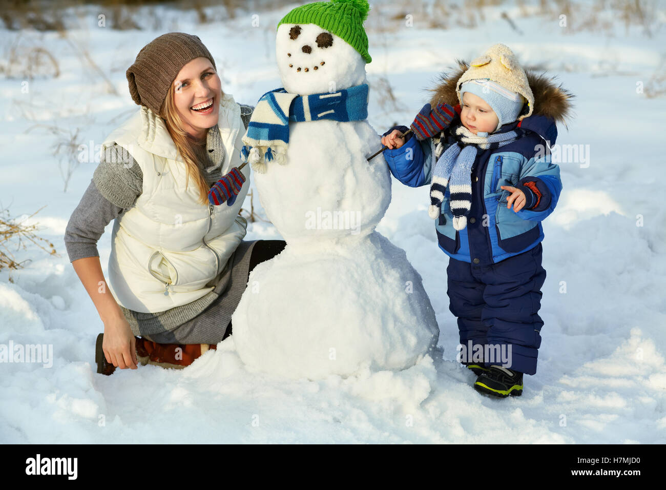 mother and baby with snowman Stock Photo - Alamy