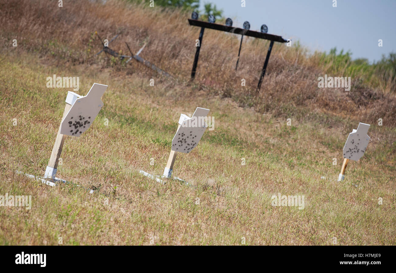 Three steel silhouette tagets with a group of plates behind for gun ...