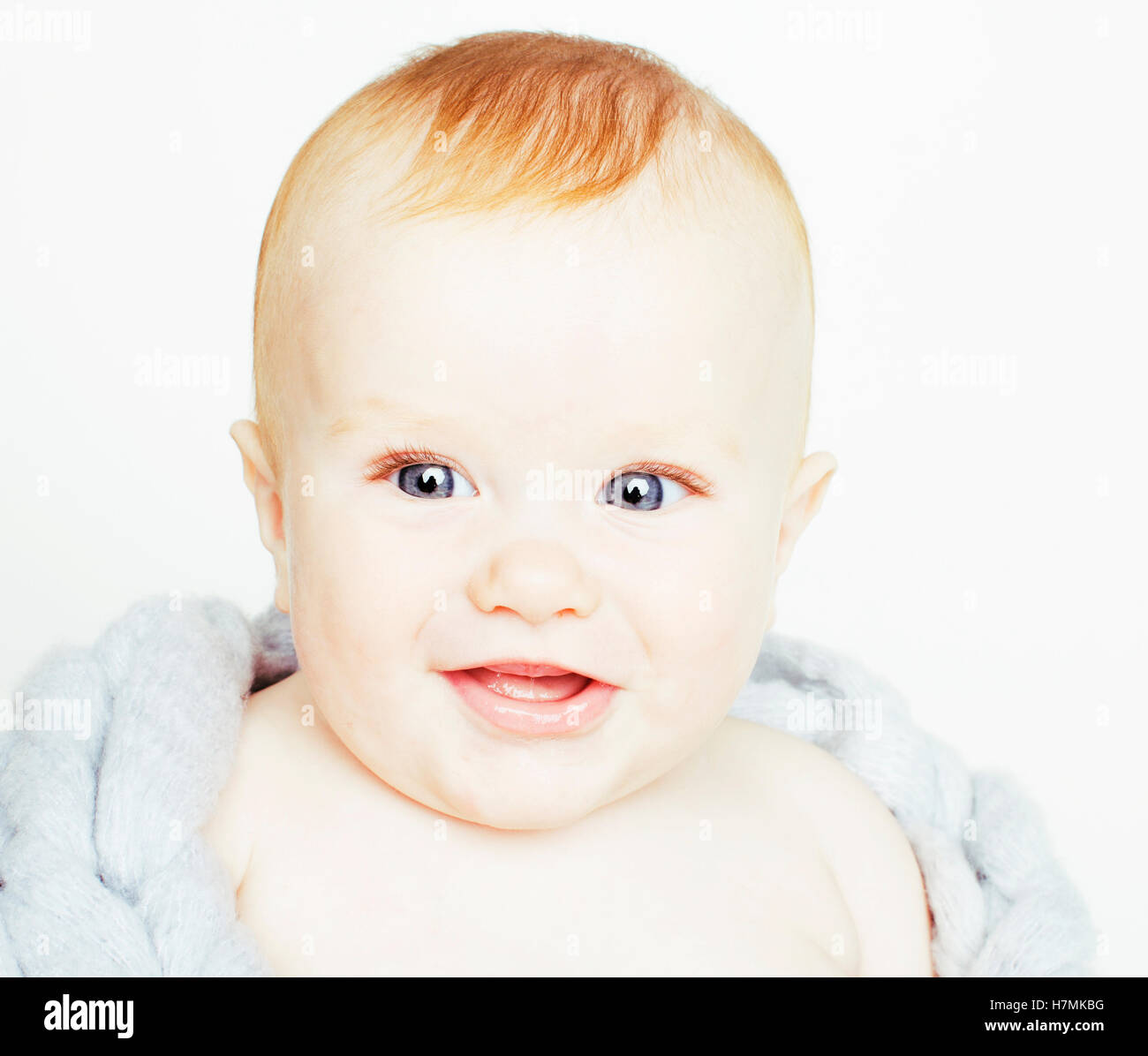 little cute red head baby in scarf all over him close up isolate Stock ...
