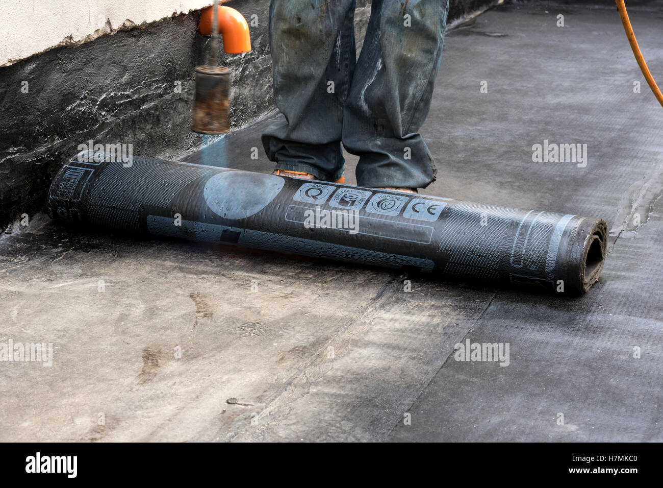 worker while burning the waterproof membrane on a roof Stock Photo - Alamy