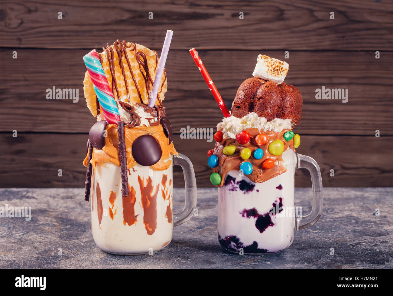 Two homemade extreme milkshakes jars on table Stock Photo - Alamy