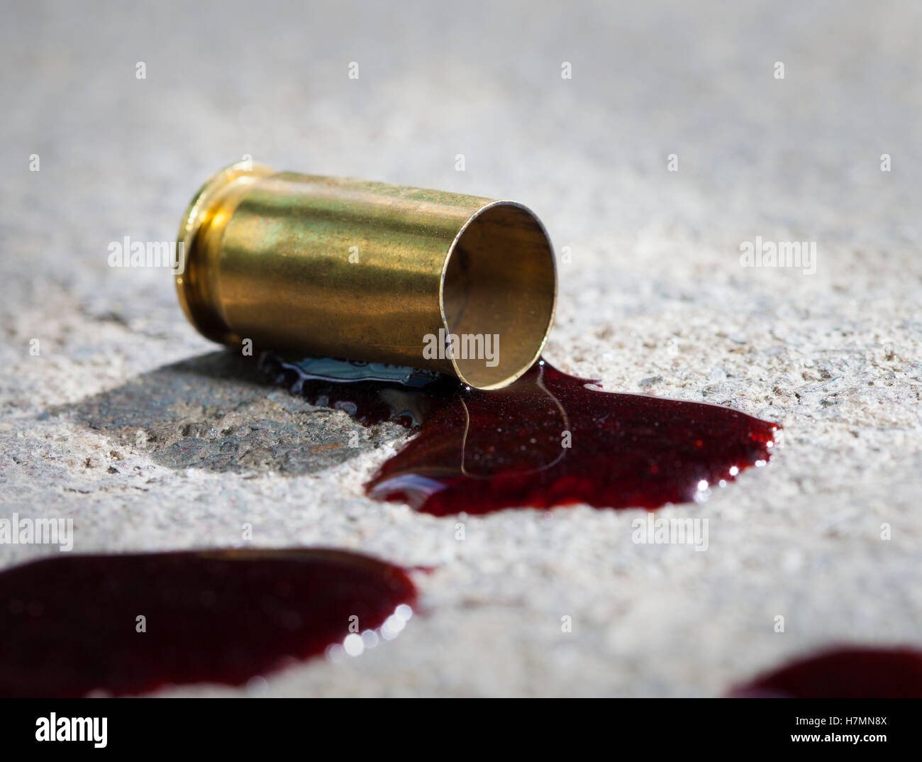 Single piece of handgun brasa on concrete with blood around Stock Photo ...