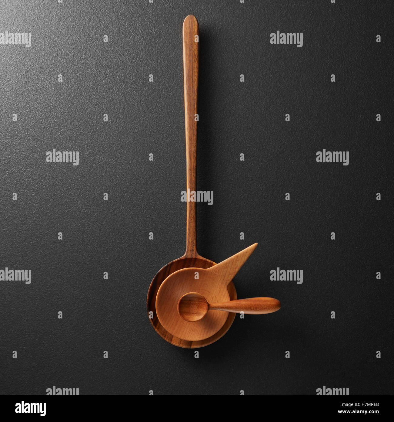 Clock made of wooden spoons on a black background concrete Stock Photo ...