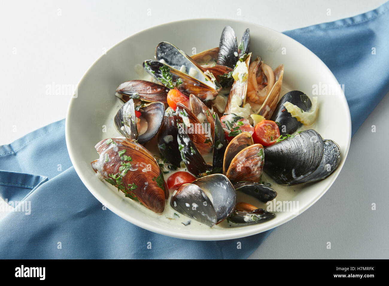 Serving of fresh cooked blue mussels in plate on white background Stock ...