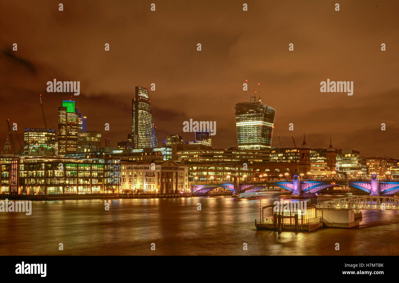 Night skyline of London as seen from the Thames riverbank, England ...