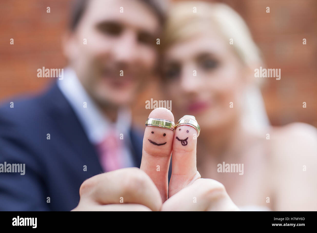 Smileys painted on married couple's thumbs Stock Photo - Alamy