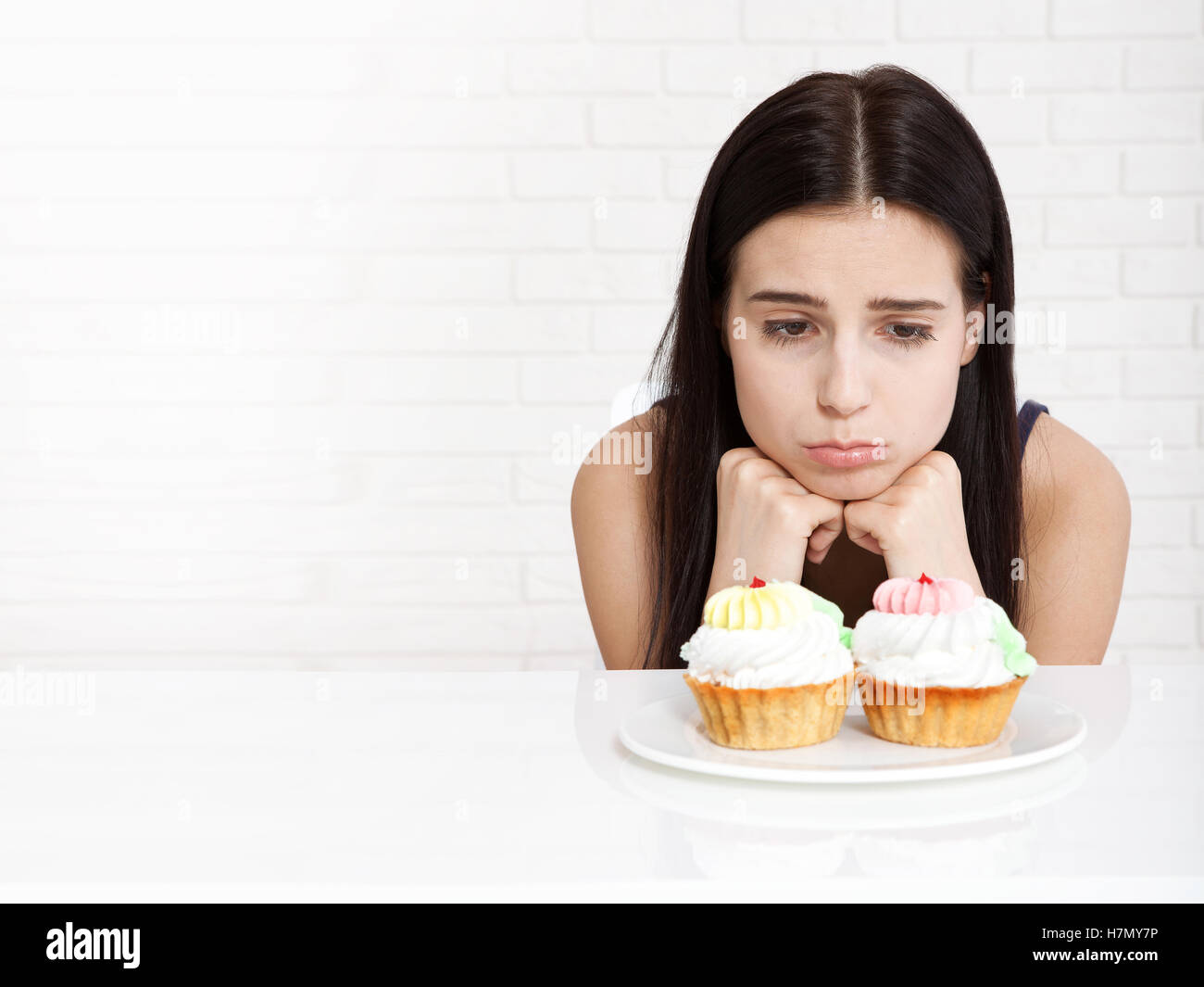 Woman with cake close-up face. Beautiful women sadly looks at cake ...