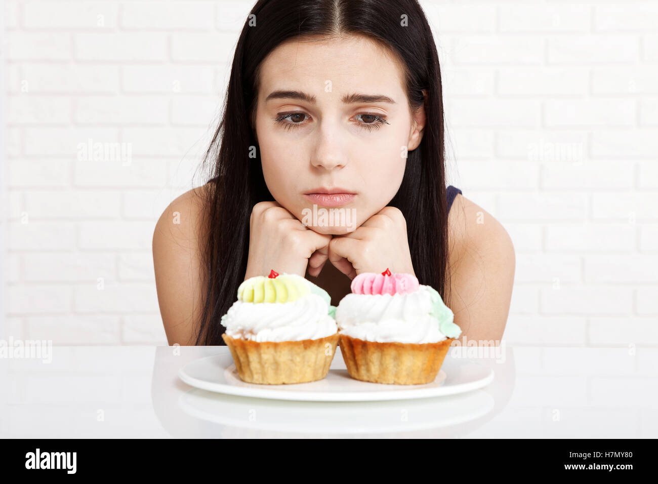 Woman with cake close-up face. Beautiful women sadly looks at cake ...