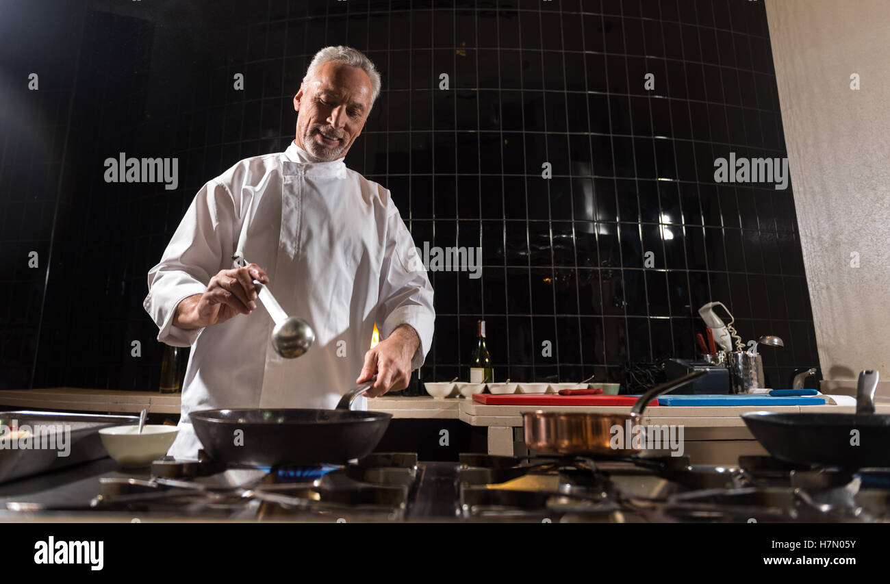Smiling chef cooking in the kitchen of the restaurant Stock Photo - Alamy