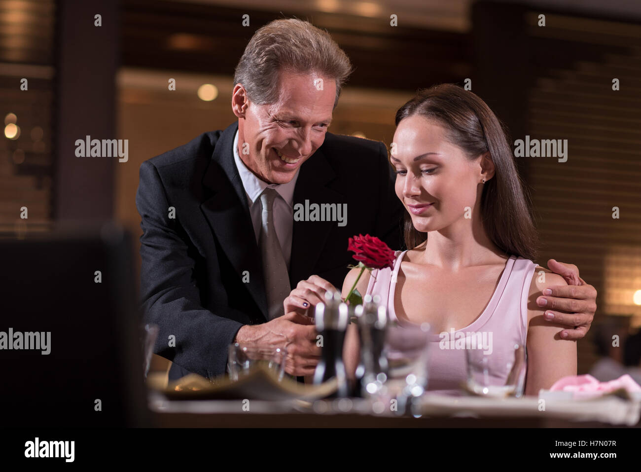 Smiling positive man giving a rose to the woman Stock Photo - Alamy