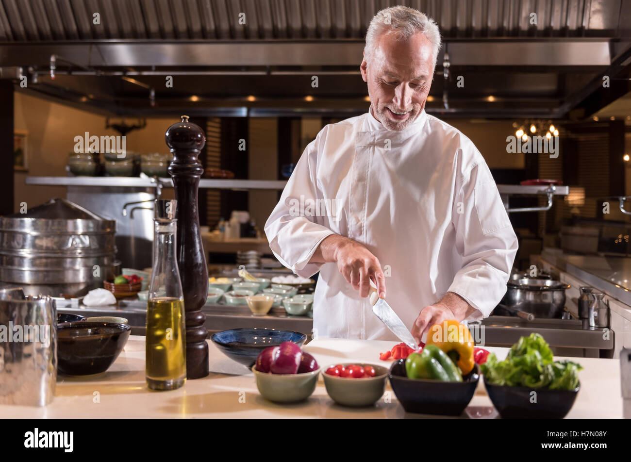 Delighted chef cutting paper in the kitchen of the restaurant Stock ...