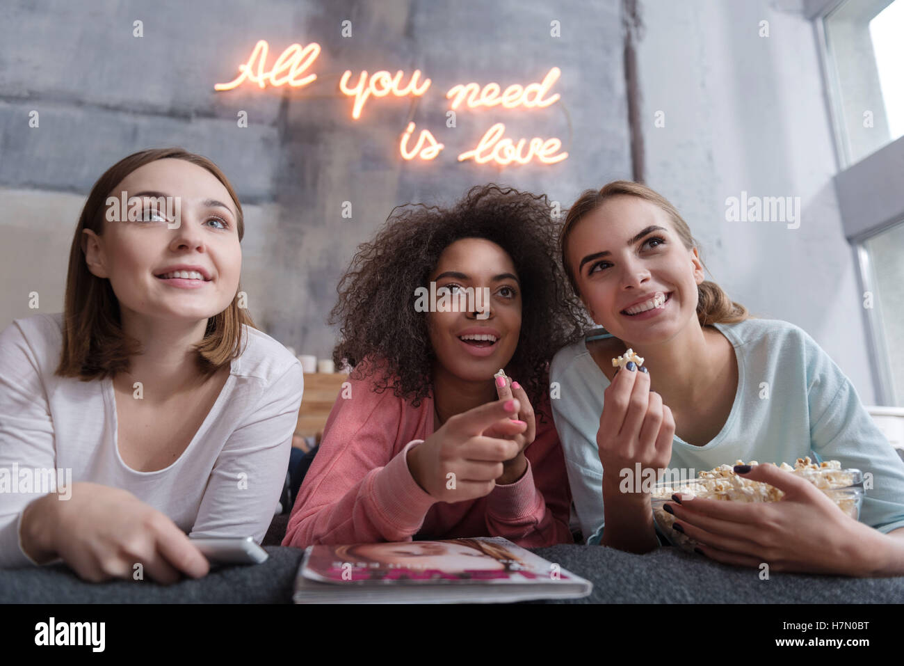 Cheerful friends watching exciting movie at home Stock Photo - Alamy