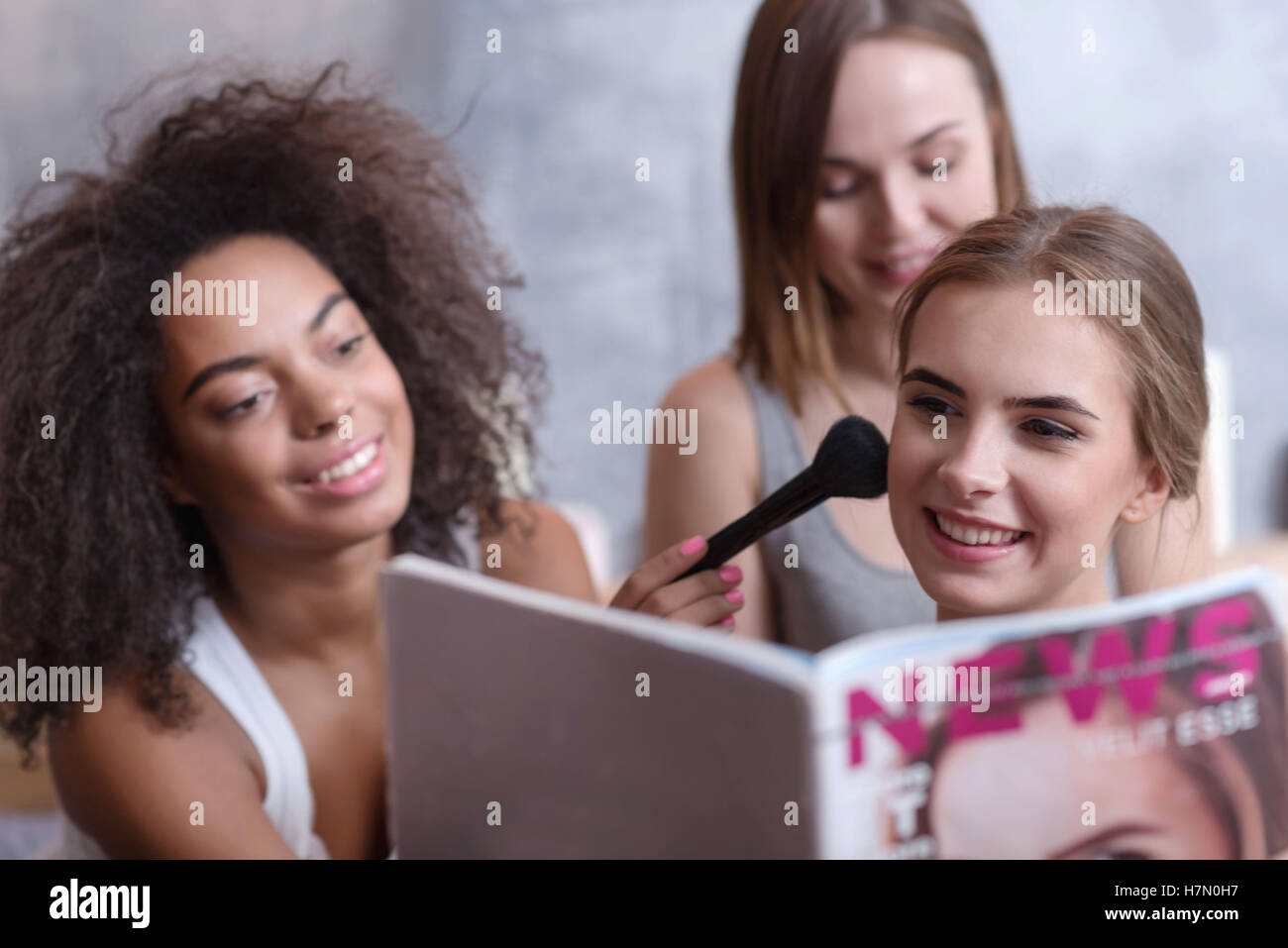 Smiling young girls reading the magazine in the bedroom Stock Photo - Alamy