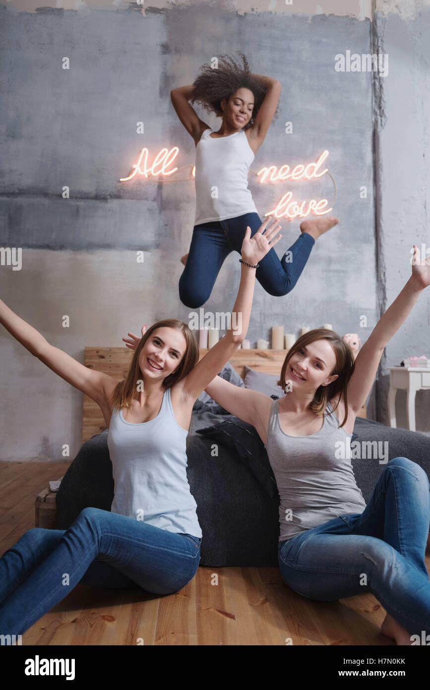 Amused girl jumping and having fun with friends Stock Photo - Alamy