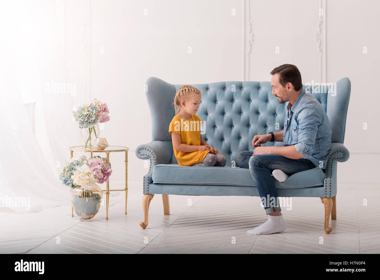 Cute small child sitting opposite her father Stock Photo - Alamy