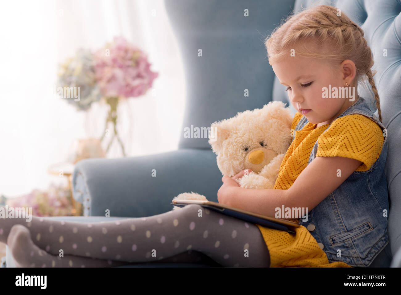 Pleasant cute girl looking at the tablet Stock Photo - Alamy