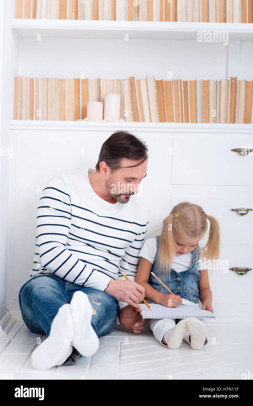 Intelligent handsome father drawing with his daughter Stock Photo - Alamy
