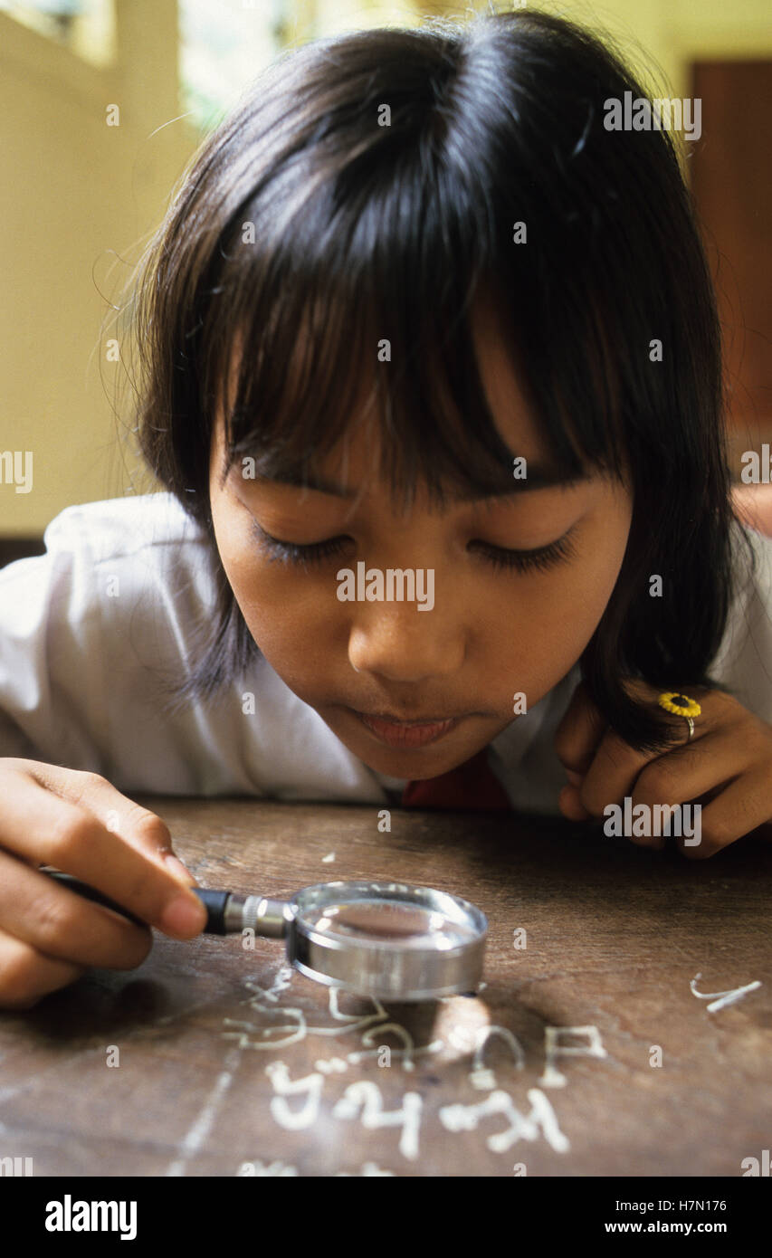Indonesia Java Jakarta, girl with Magnifying glass in class in school ...