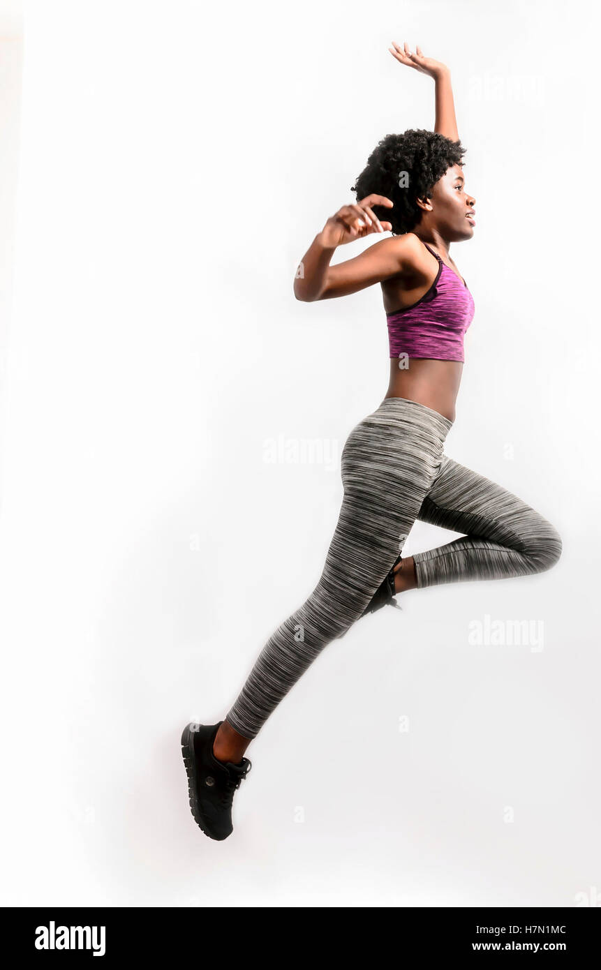 fit black woman jumping on white background Stock Photo - Alamy