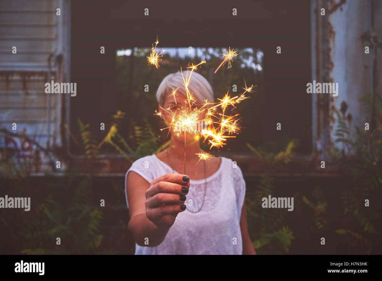Blonde woman having fun with a sparkler Stock Photo - Alamy